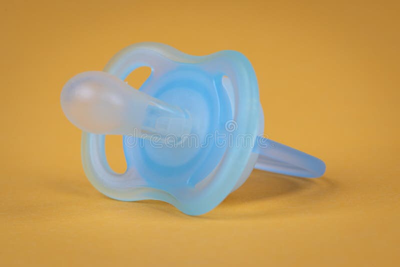 Baby Blue Pacifier on a Yellow Background Stock Photo - Image of rubber ...