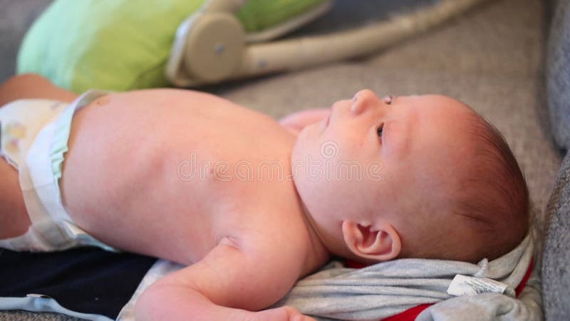 Baby Boy in Diaper Lying on His Back on the Couch Stock Video - Video ...