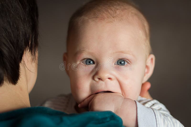 Baby Boy in Mother& X27;s Arms Looking Over Her Shoulder Stock Photo ...
