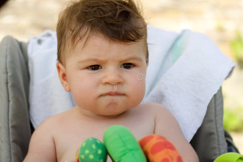 Baby Boy Sitting on a Stroller with Sulky Expression Stock Photo ...