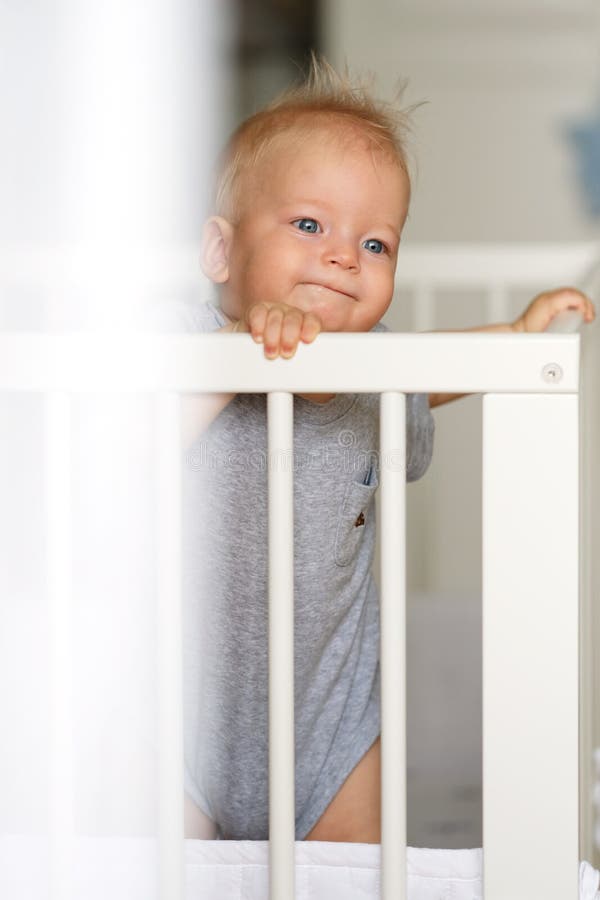 Baby boy standing in crib stock image. Image of beautiful - 84575879