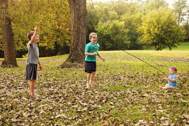 Baby and boys jump rope stock image. Image of green, recreation - 99232385