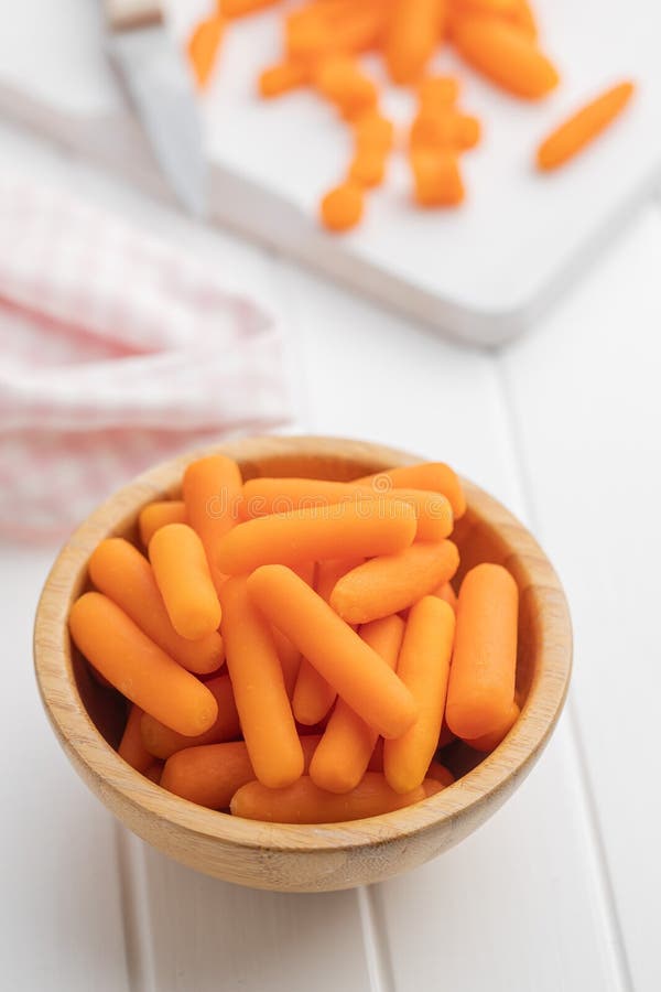 Baby Carrot Vegetable in Bowl. Mini Orange Carrots on White Table Stock ...