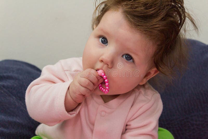 Baby chewing on the beads. stock photo. Image of closeup - 87822754