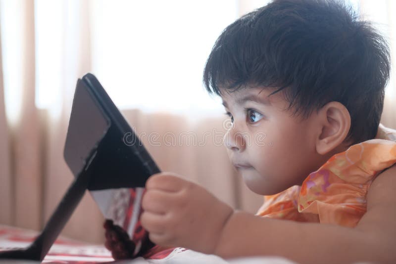 Baby Child Use Digital Tablet Laying on Bed. Stock Image - Image of ...