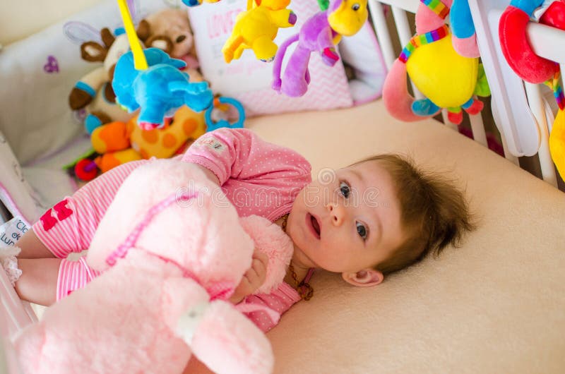 Baby in a cot stock photo. Image of playing, beautiful - 76672592
