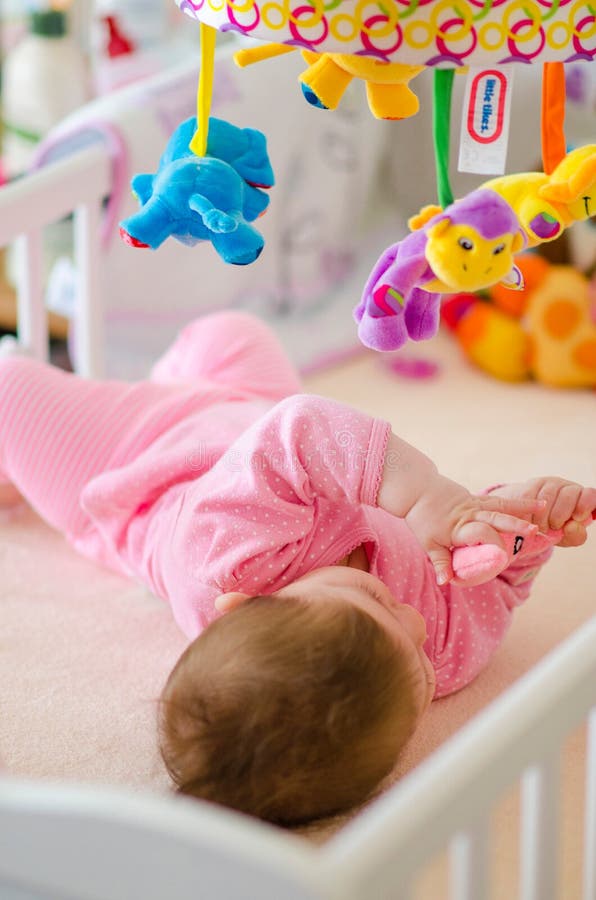 Baby in a cot stock image. Image of happy, home, toys - 76672683