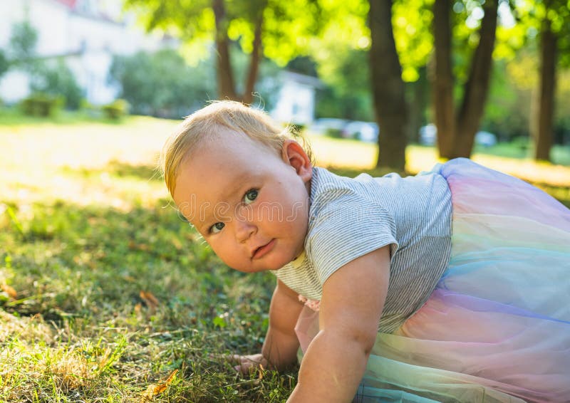 Baby Crawling on Green Grass in a Sunlit Park Surrounded by Trees Stock ...