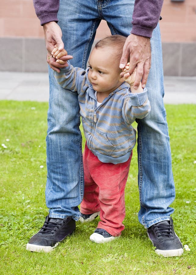 Loopbaan. Het Leren Van Kinderen Om Te Lopen. Vader Houdt Een Kind Vast ...
