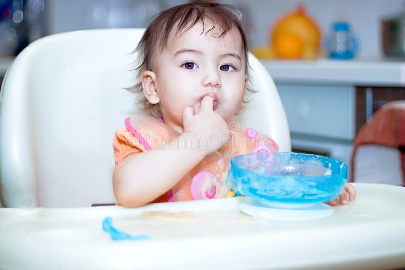 Baby Eating in the Kitchen on the Sittting on the Table Stock Image ...