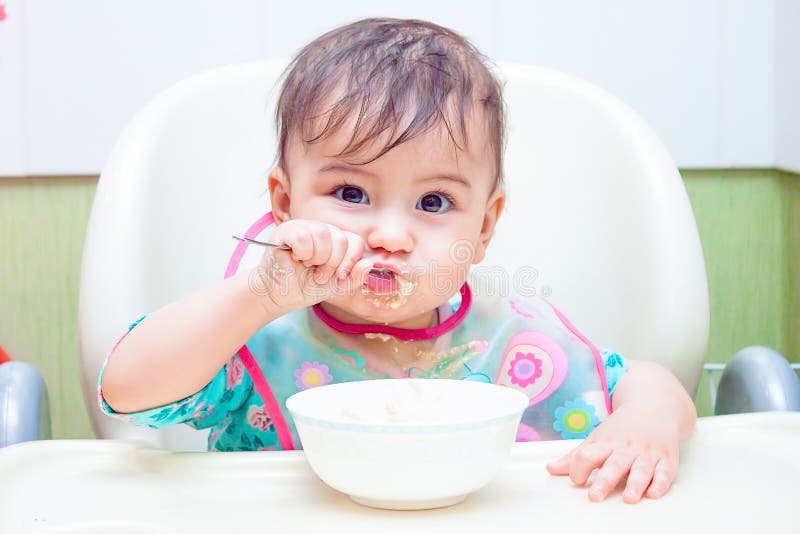 Baby eating spoon stock image. Image of expression, family - 94761765