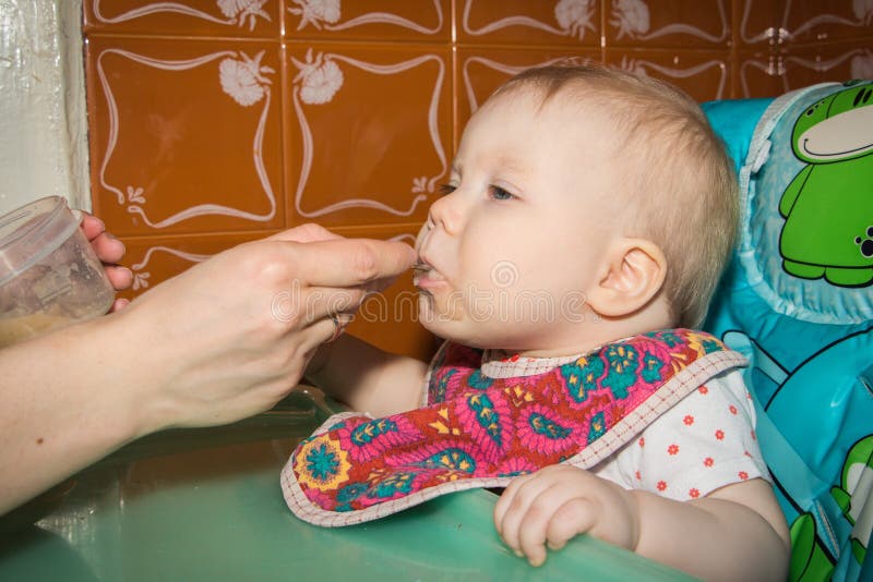 Baby eats puree from spoon stock image. Image of kitchen - 96962475