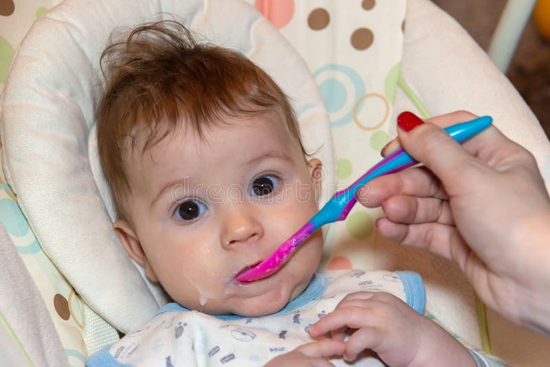 The Baby Eats Solid Food for the First Time Stock Photo - Image of ...