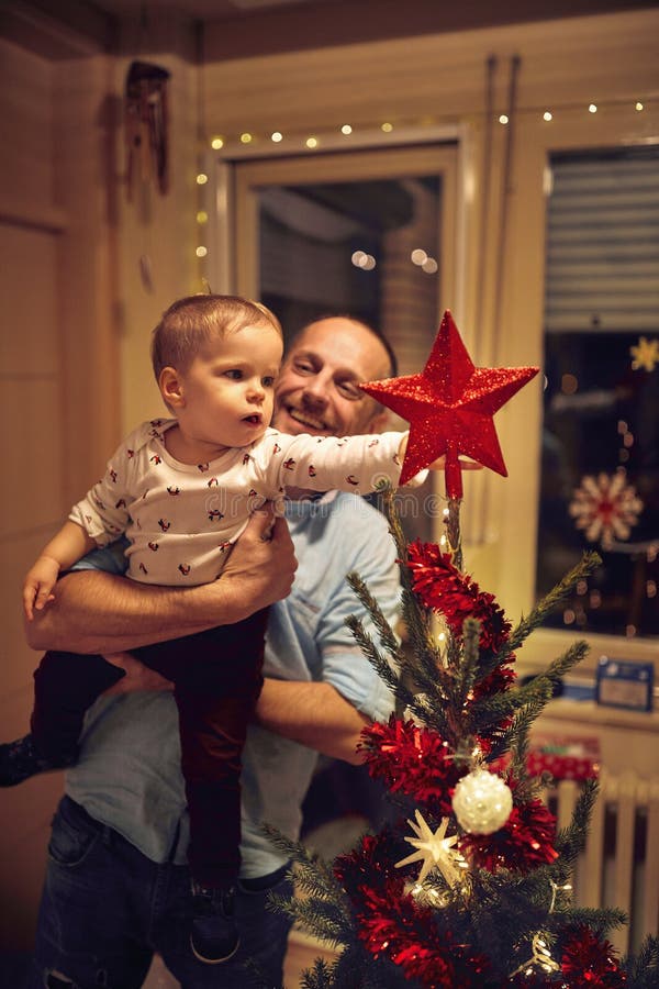 Baby and Father Putting a Star on the Top of the Christmas Tree Stock ...