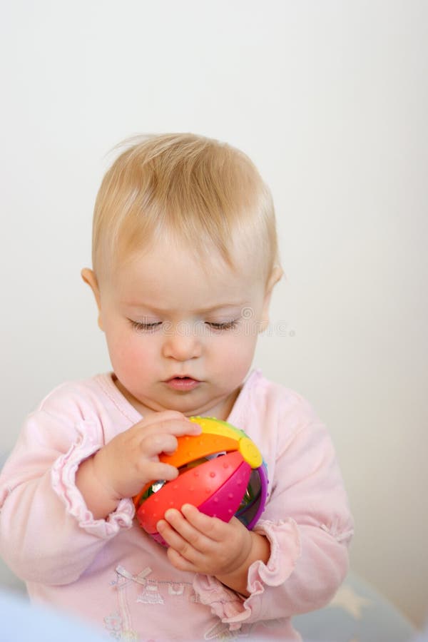 Baby girl playing with toy stock photo. Image of playing - 26303748