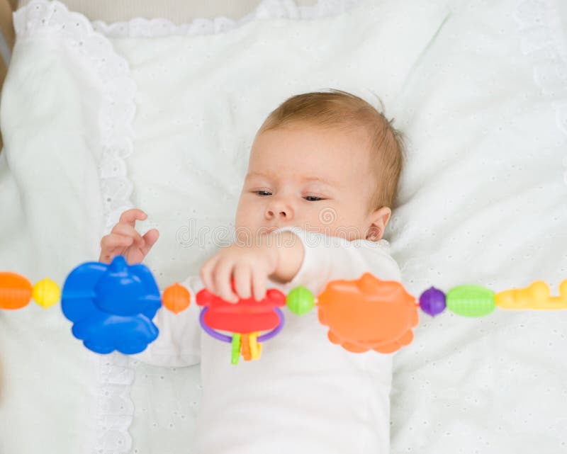 Baby Girl Playing with Toy Rattle Lying on Back Stock Image - Image of ...