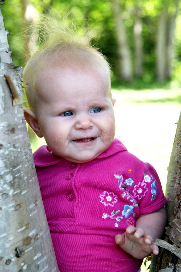 Baby Girl Posing Next To Tree Stock Photo - Image of beautiful, mouth ...