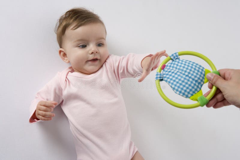 Baby girl reaching for toy stock image. Image of girl - 15324335