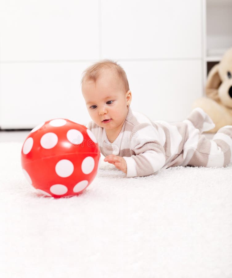 Baby girl with red ball stock photo. Image of curious - 24996816