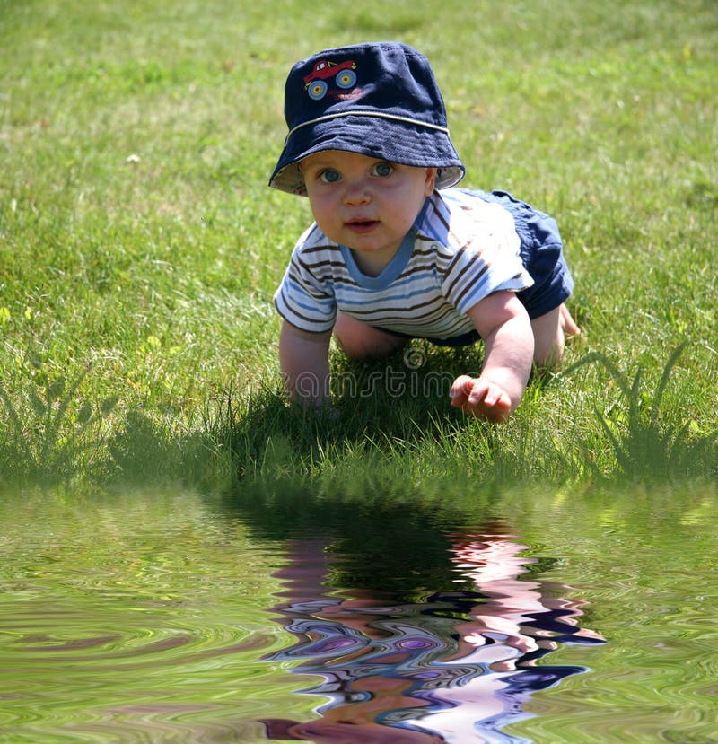 Baby in the Grass by Water stock image. Image of people - 2991943