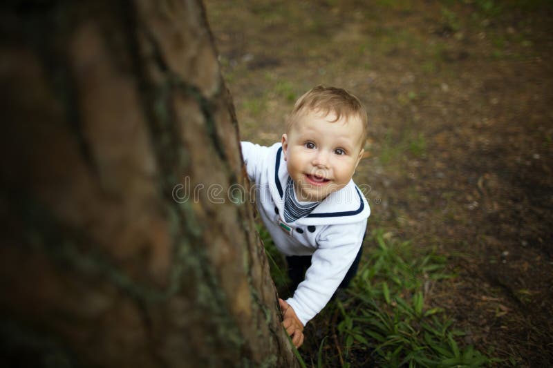 Baby Hiding Behind Tree in Park Stock Photo - Image of baby, nature ...