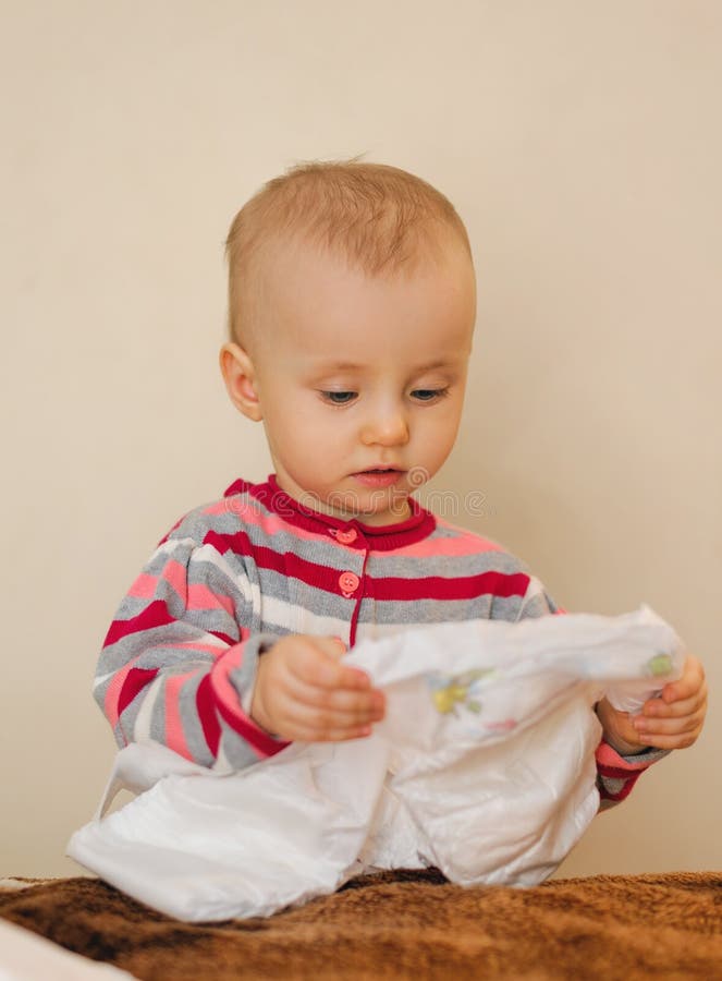 Baby Holding a Nappy in Hand and Looking Stock Image - Image of lovable ...