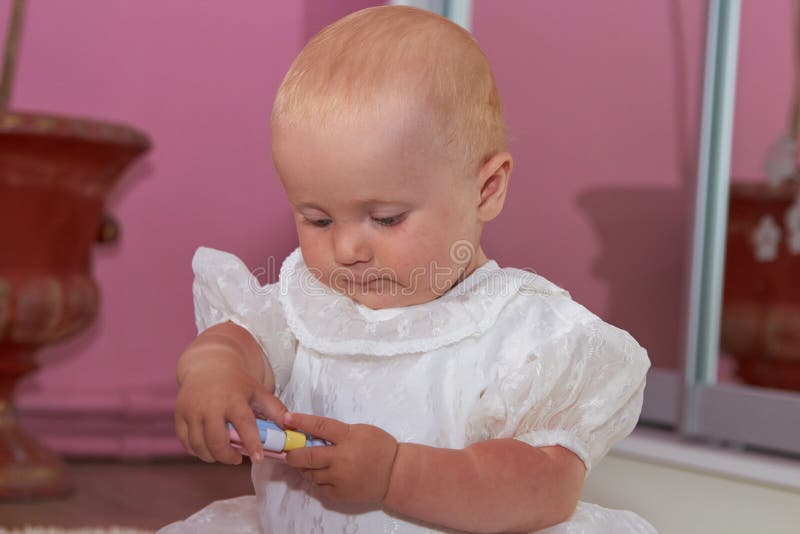 Baby Holding a Baby Rattle,interested Baby Examines the Toy in His ...