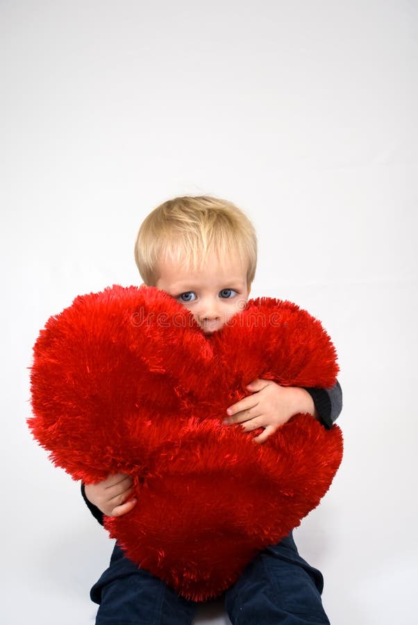 Baby hugging a plush heart stock photo. Image of child - 12983224