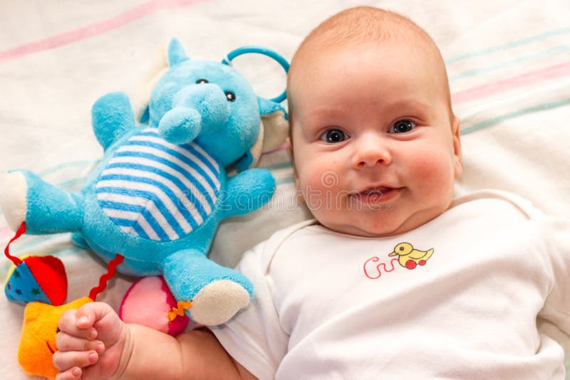 Baby Lies with Toy Blue Elephant Stock Image - Image of childhood, hand ...