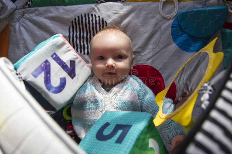A Baby Looking at the Camera Playing on a Sensory Development Activity ...