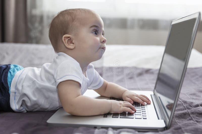 The Baby Looks with Interest at the Laptop Screen. New Generation Stock ...