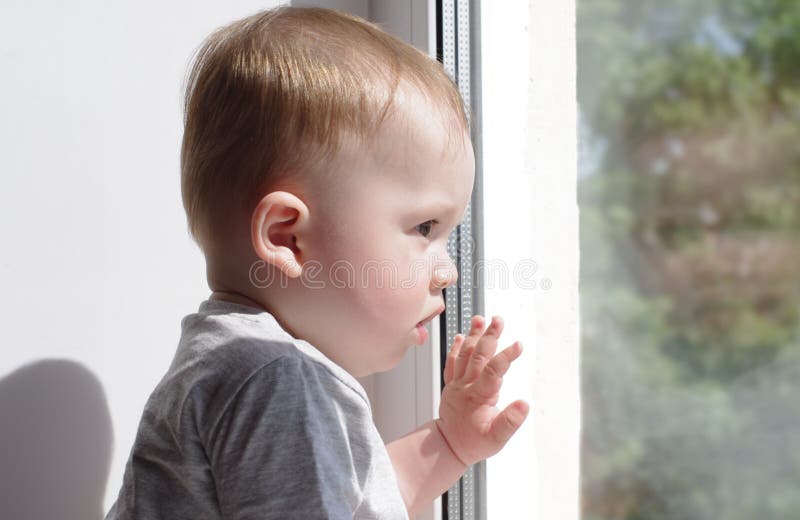 Baby looks out of window stock image. Image of wait, window - 33881619