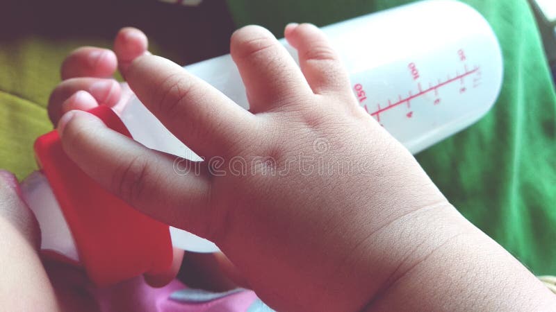 Baby with milk in hand stock photo. Image of child, breastfeeding ...