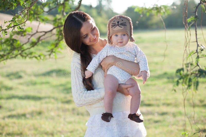 Baby and Mother Under the Tree Stock Image - Image of holding, fashion ...