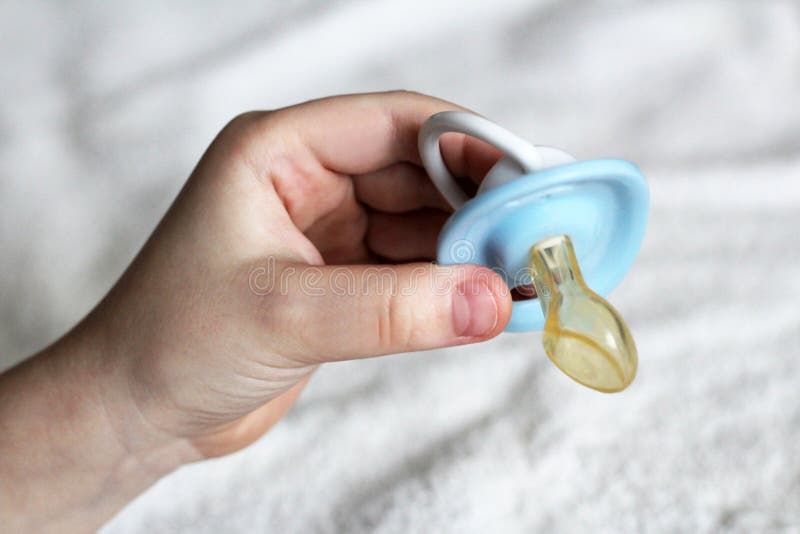 Baby Pacifier in Hand on White Background Stock Image - Image of ...