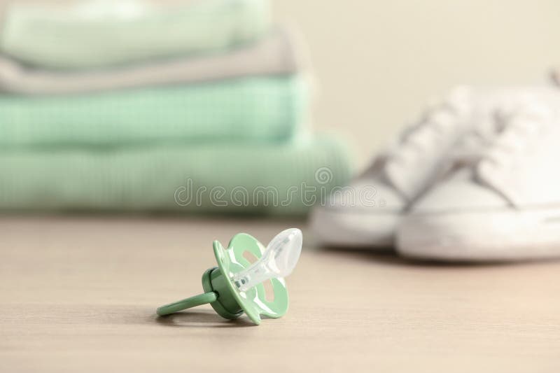 Baby Pacifiers on Beige Table Against Blurred Background, Space for ...