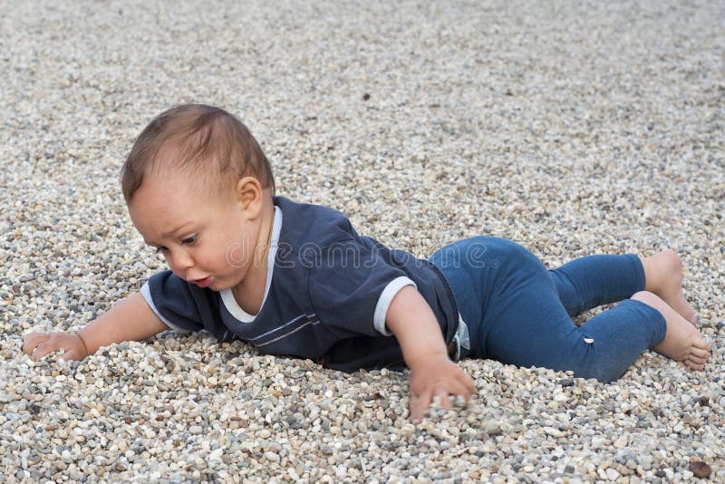 Baby in pebbles stock image. Image of beach, shore, stone - 27720761