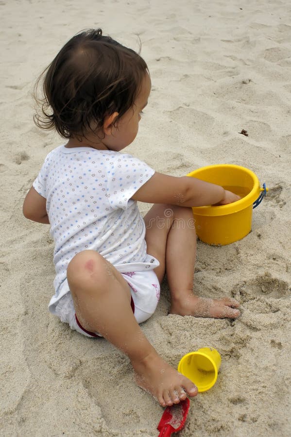 A Baby Playing on the Beach with the Sand and Water. . Stock Image ...
