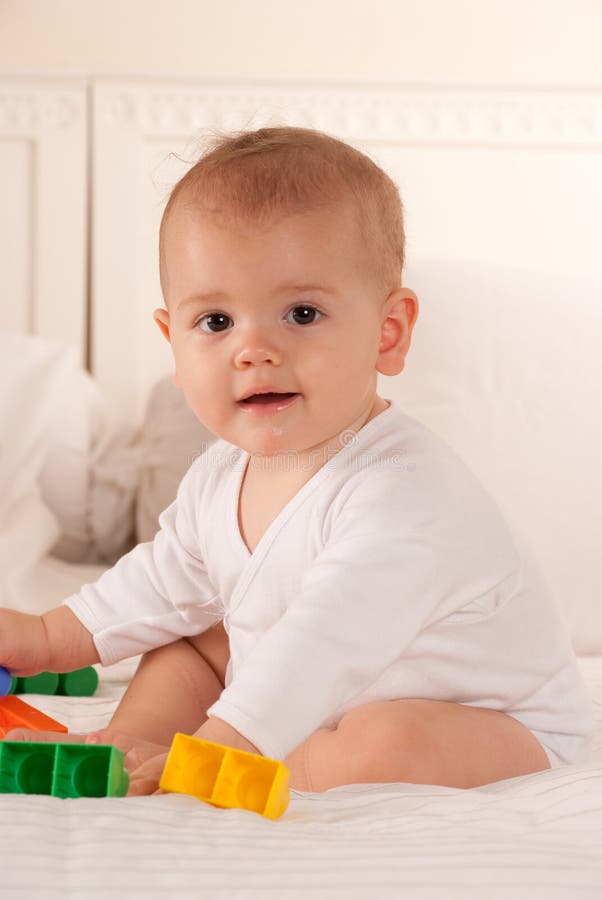 Baby playing on a bed stock photo. Image of toddler, beautify - 20191182