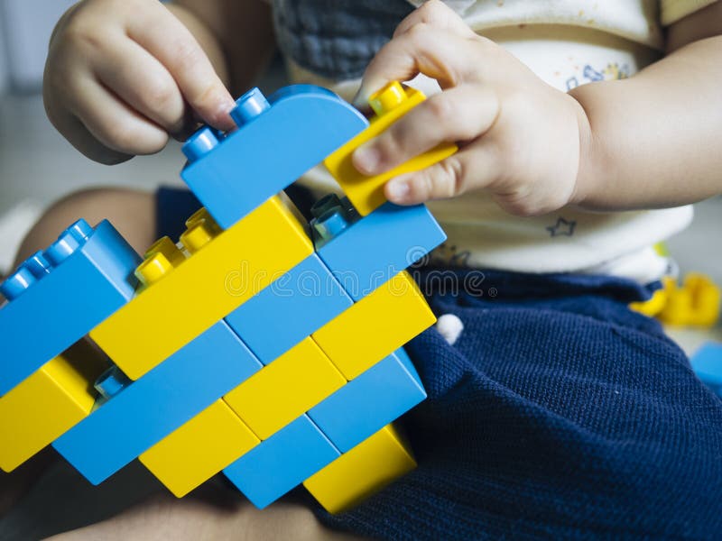 Baby Playing with Blue and Yellow Lego Bricks Stock Image - Image of ...