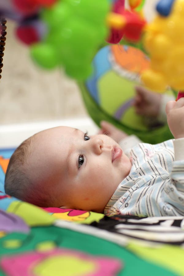 Baby on playing mat stock image. Image of expression - 24229617
