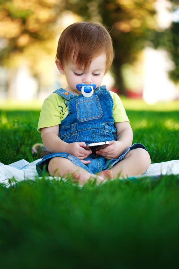 Baby is Playing with Phone on the Green Grass Stock Photo - Image of ...