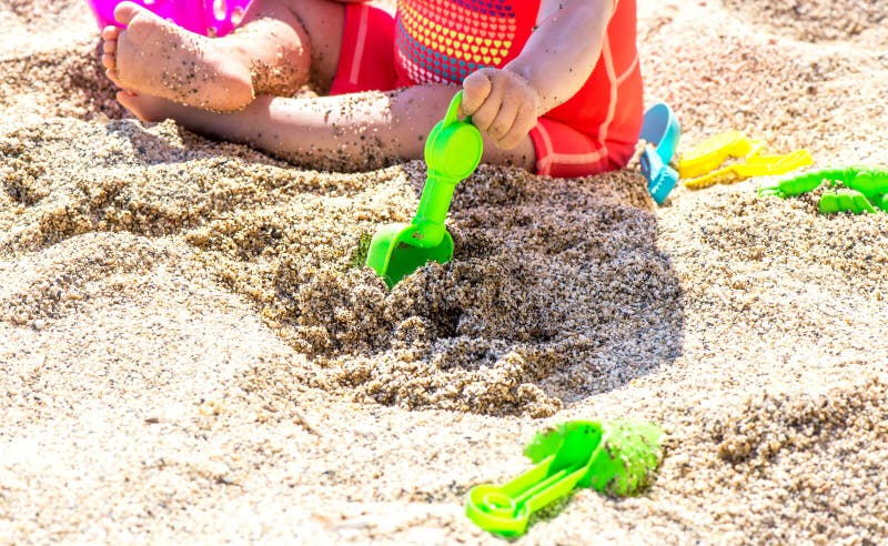 Baby playing in the sand stock image. Image of shovel - 78162685