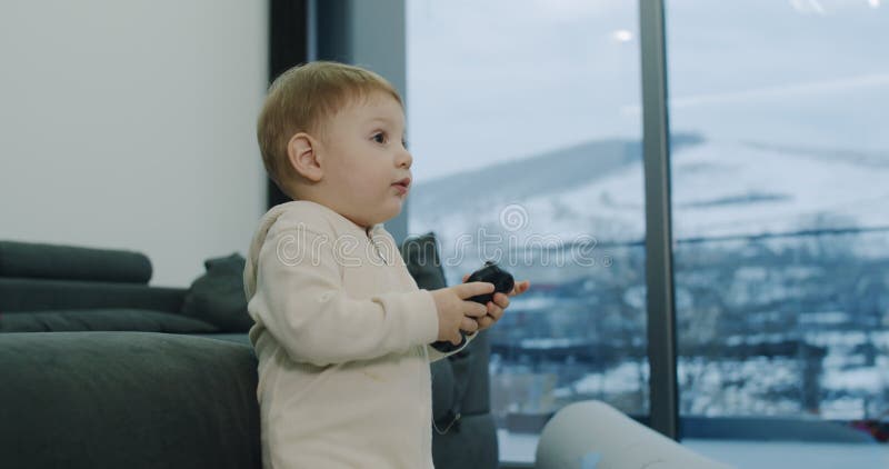 A Baby Plays Joyfully with a Game Controller, Exploring New Worlds ...