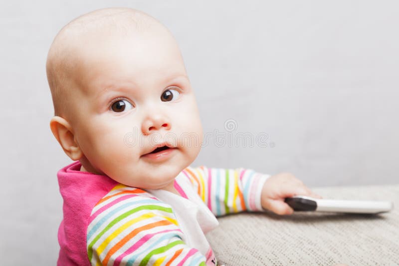 Casual Baby Sitting on a Couch Touching a Mobile Phone Stock Image ...