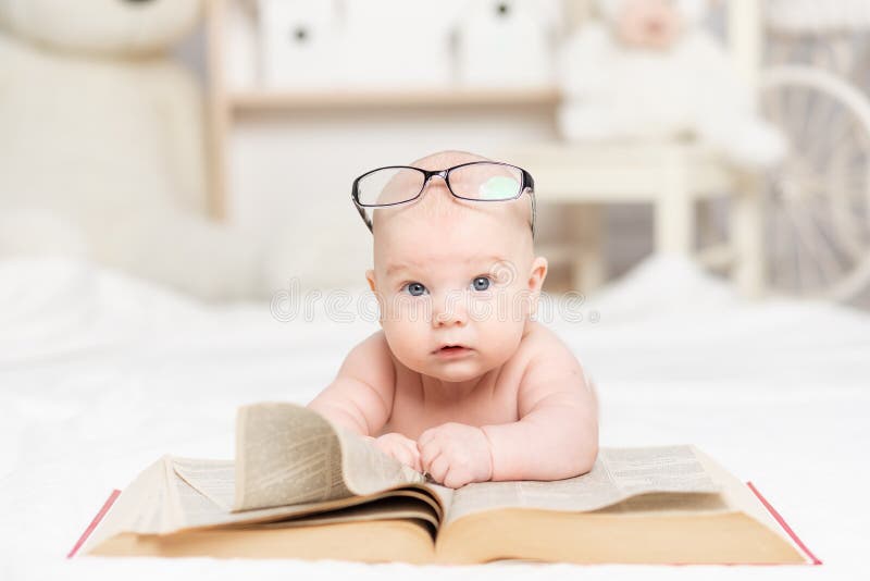 Baby Reading a Book or Looking at it in the Nursery, Learning and ...