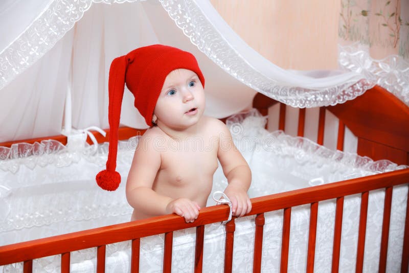Baby in Red Cap Smiling in Bed Stock Photo - Image of innocence ...