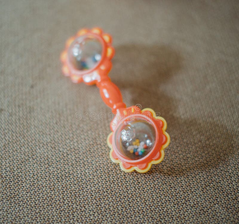 Baby Red Yellow Rattle Lies on the Fabric Stock Photo - Image of ...