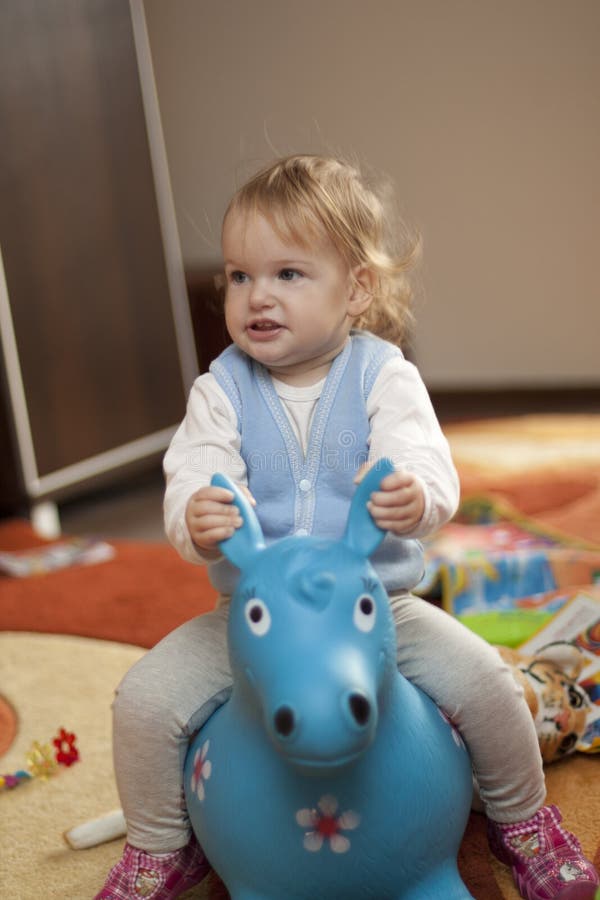 Baby riding a toy horse stock image. Image of home, soft - 23490317