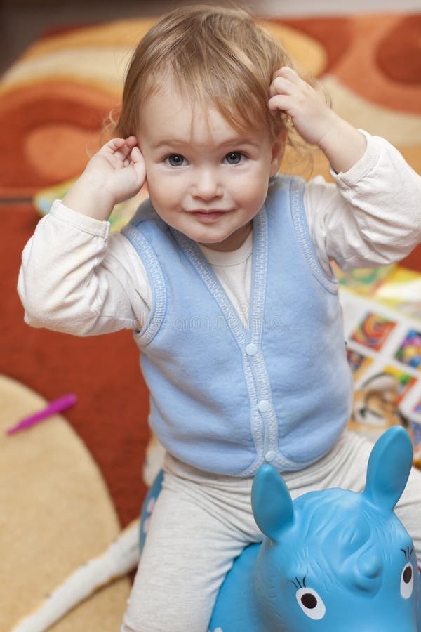 Baby riding a toy horse stock image. Image of horse, girl - 23490333